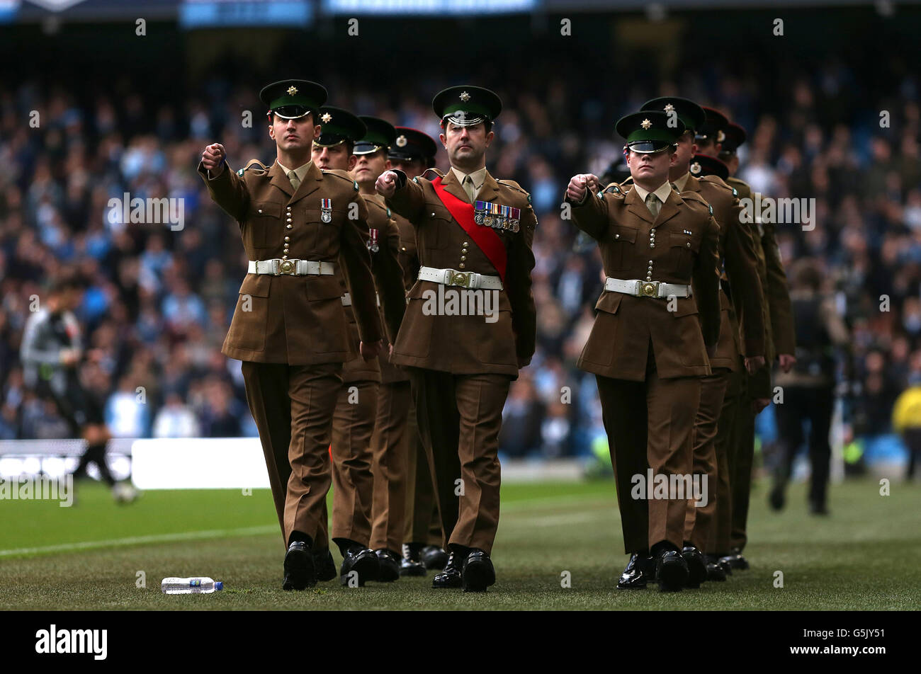 Members of the Armed forces march around the pitch on Remembrance ...