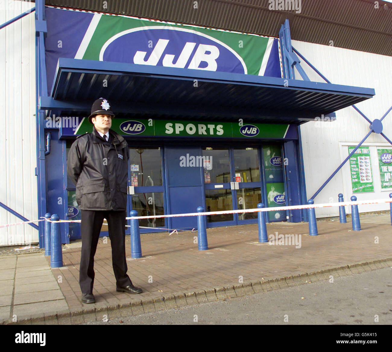 A police officer stands outside the JJB Sports in Alpine Way, Beckton ...