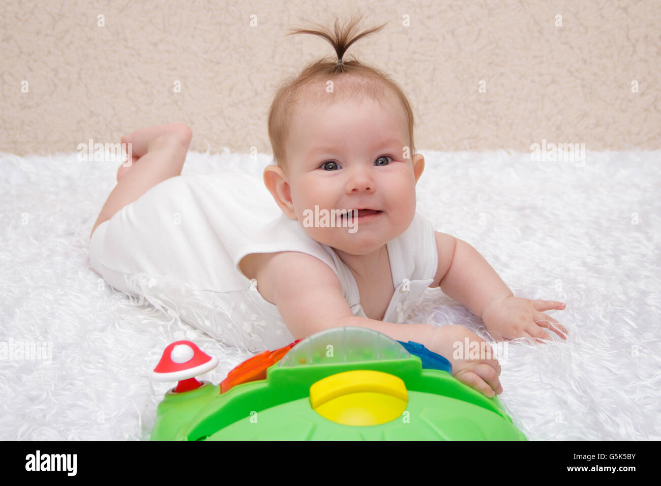 Little baby girl playing with a toy Stock Photo - Alamy