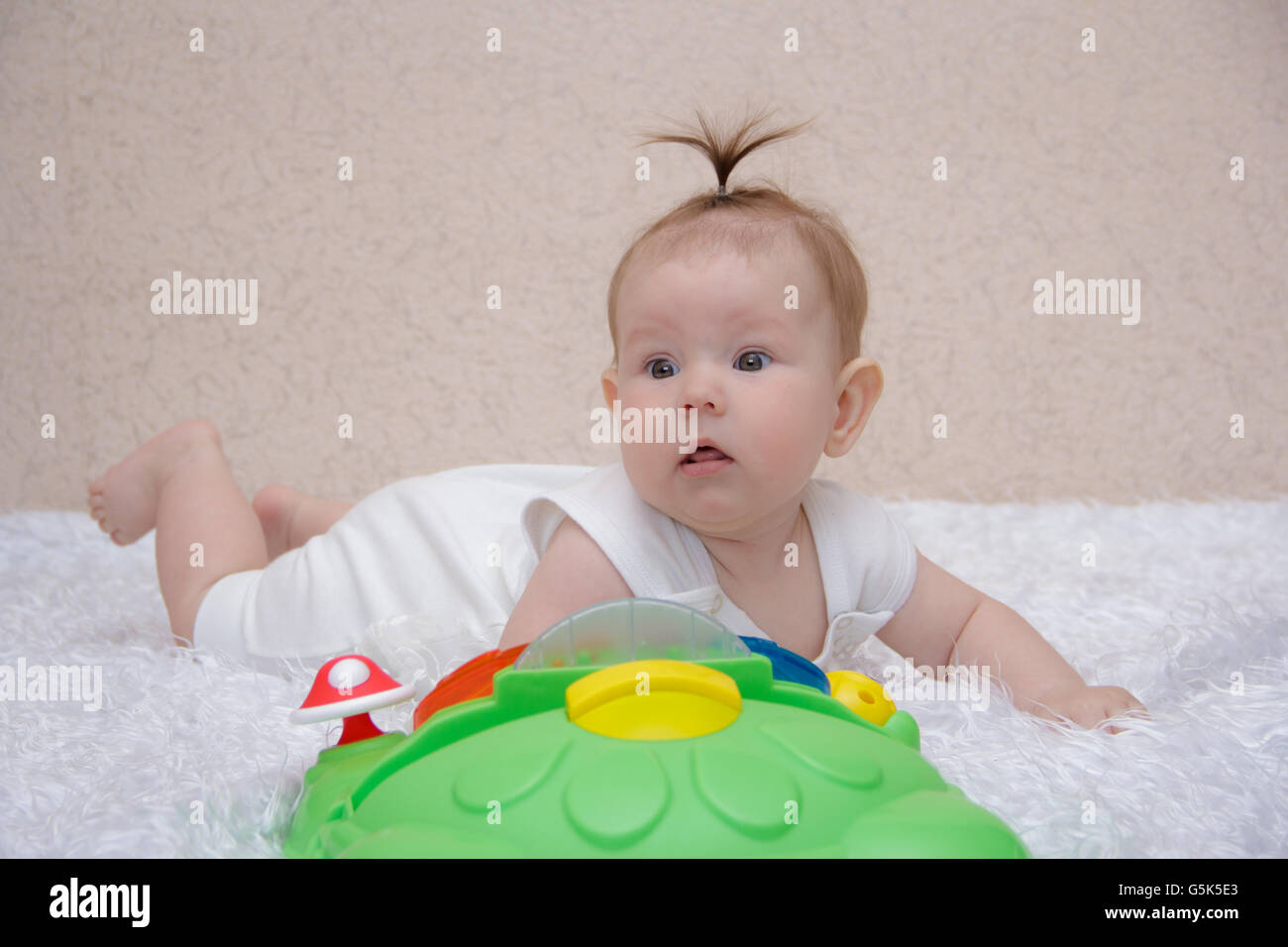 Little baby girl playing with a toy Stock Photo - Alamy