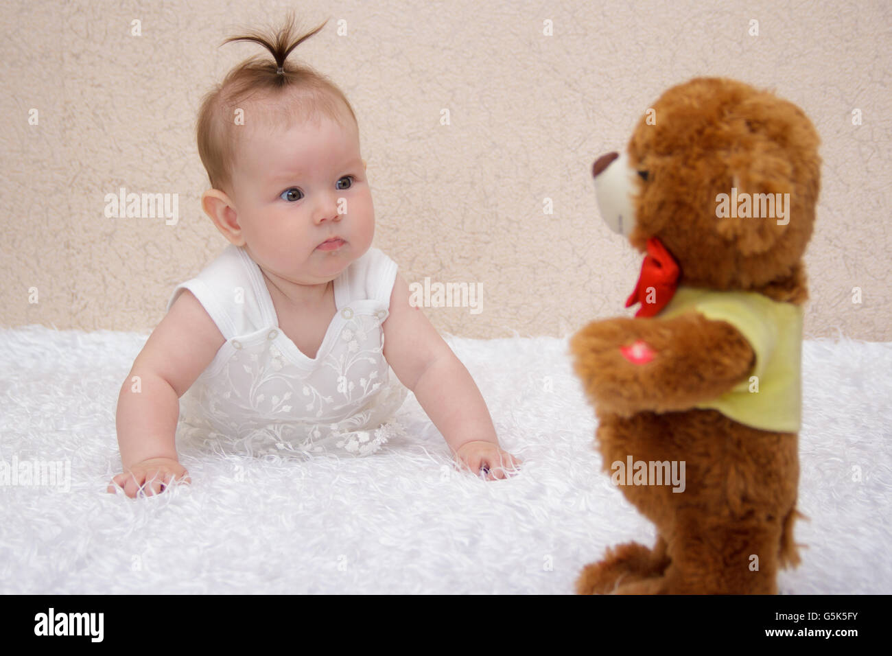 Little baby girl playing with a toy teddy bear Stock Photo - Alamy