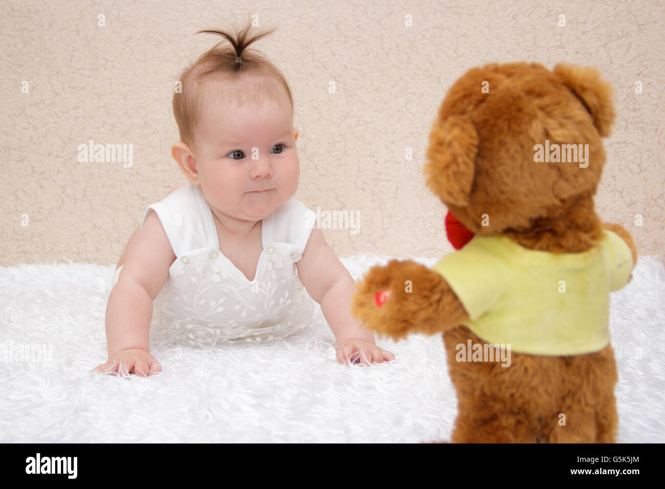 Little baby girl playing with a toy teddy bear Stock Photo - Alamy