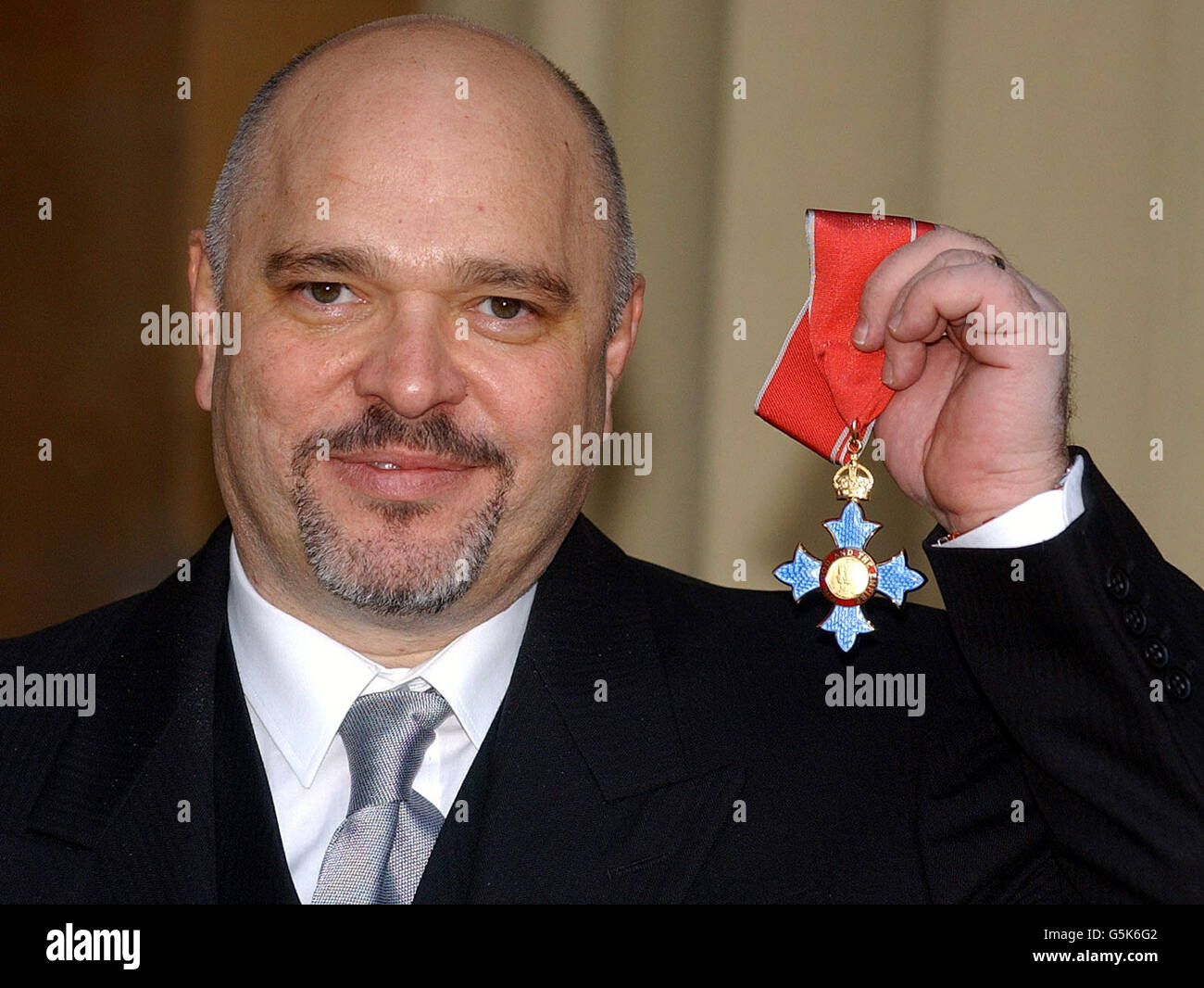 Anthony Minghella holds aloft his CBE Stock Photo - Alamy