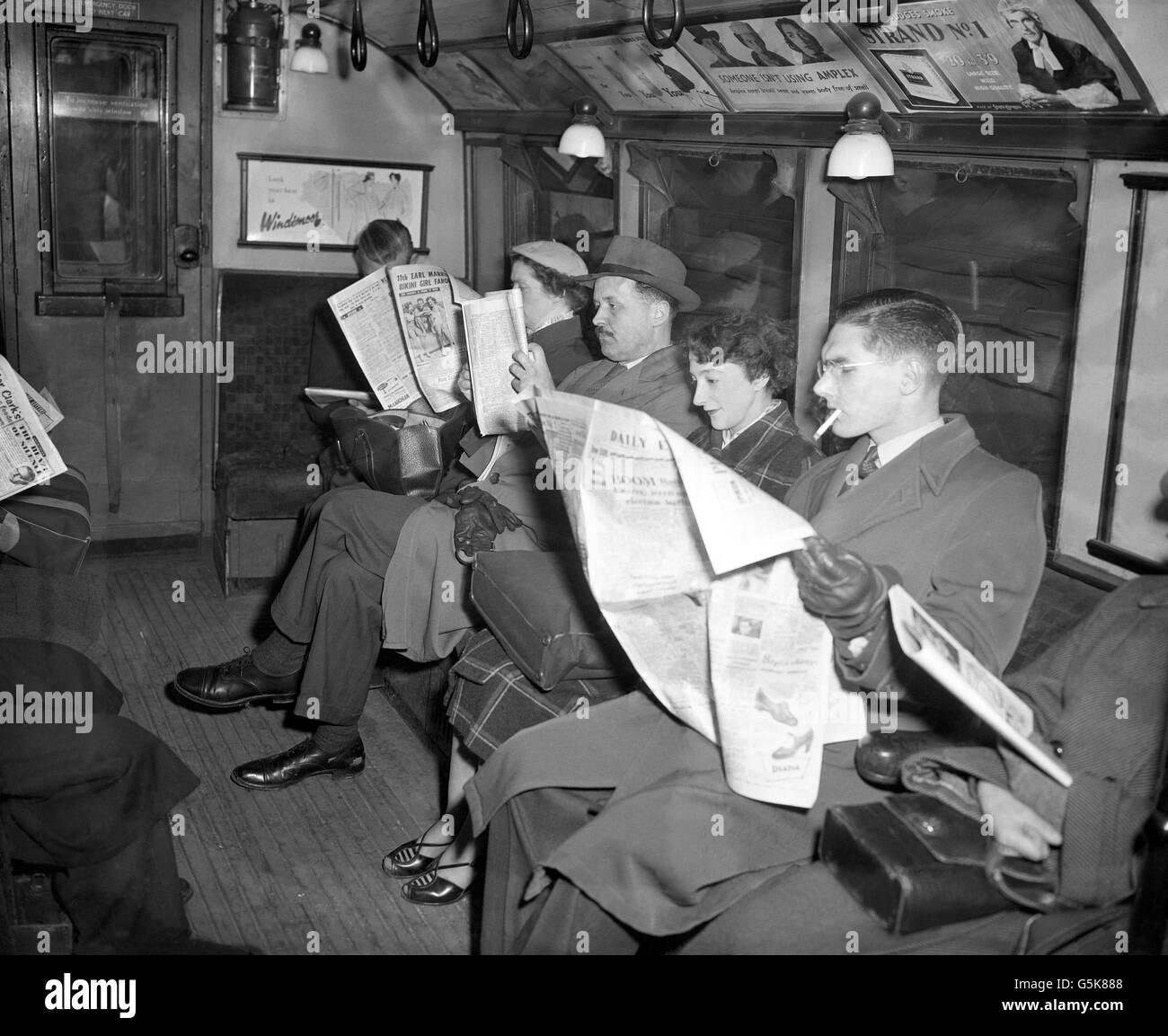 People Reading Newspaper On Train