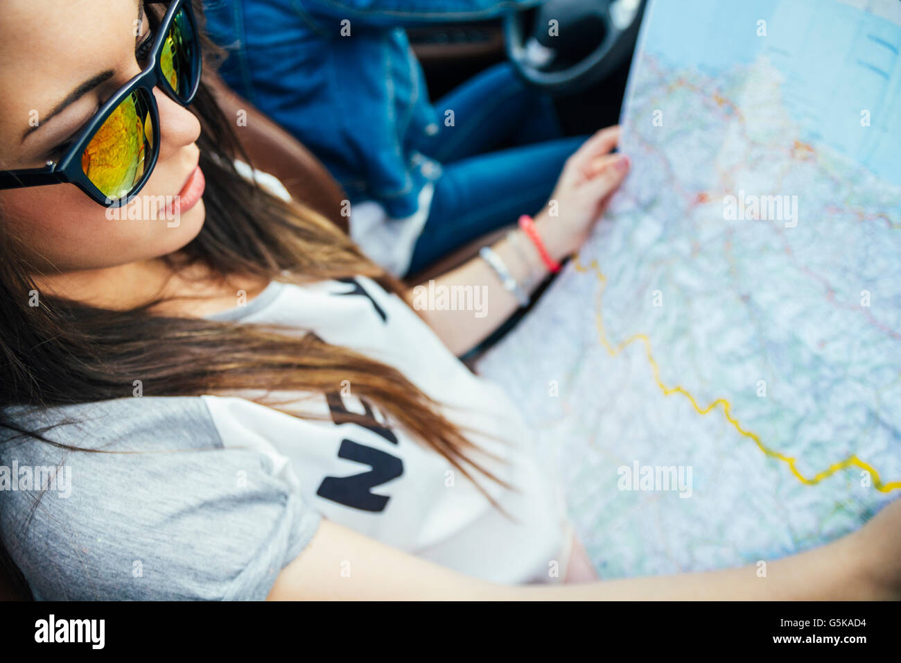 Woman reading map on road trip Stock Photo - Alamy