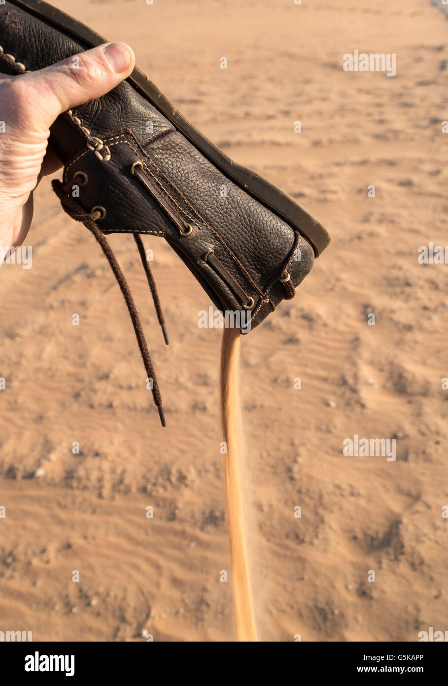 Hand pouring sand from shoe in desert Stock Photo - Alamy