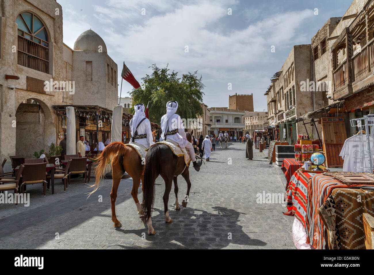Men riding horses on Doha street, Doha, Qatar Stock Photo - Alamy