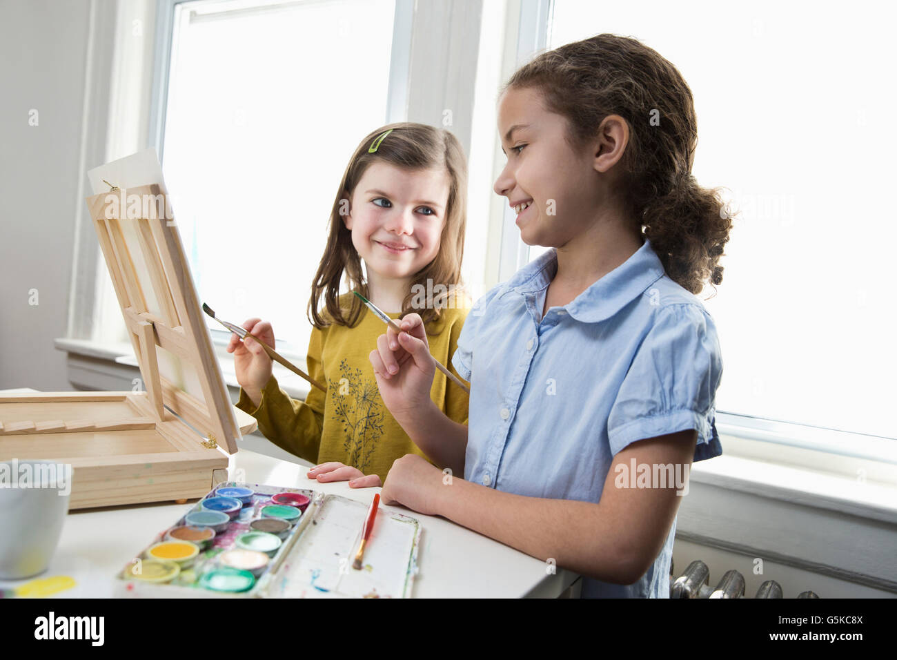 Smiling girls painting Stock Photo - Alamy
