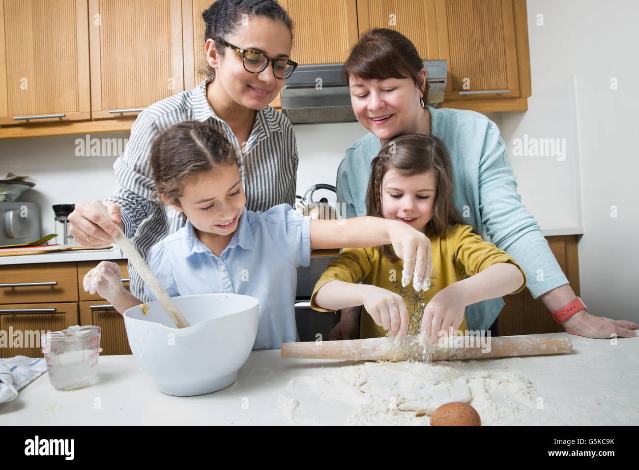Mothers teaching daughters to bake in kitchen Stock Photo - Alamy