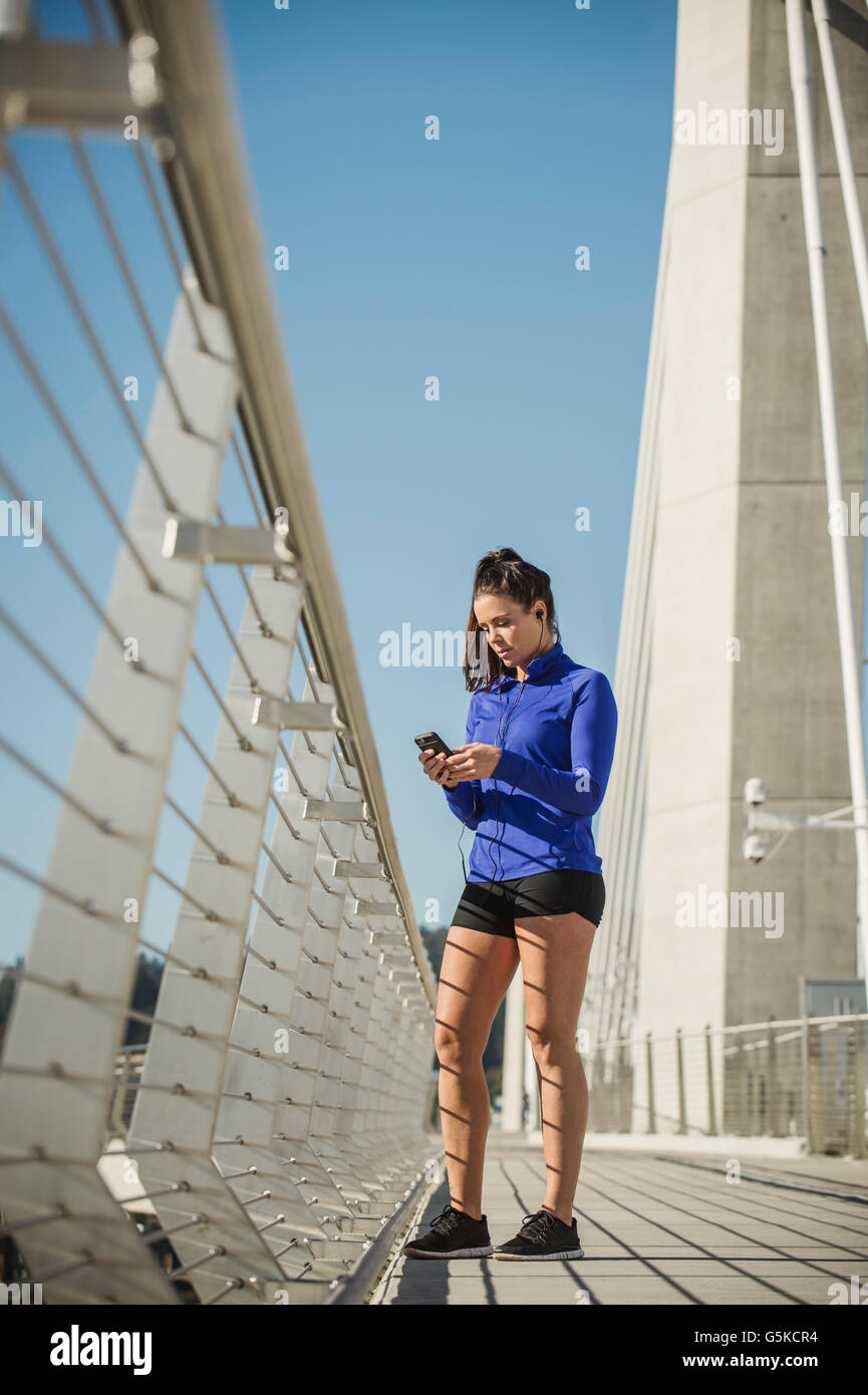 Caucasian woman using cell phone on urban bridge Stock Photo - Alamy
