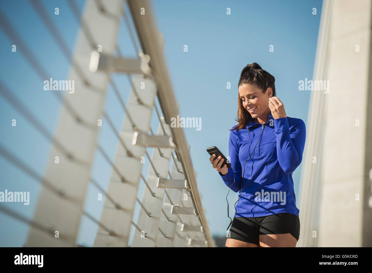 Caucasian woman using cell phone on urban bridge Stock Photo - Alamy