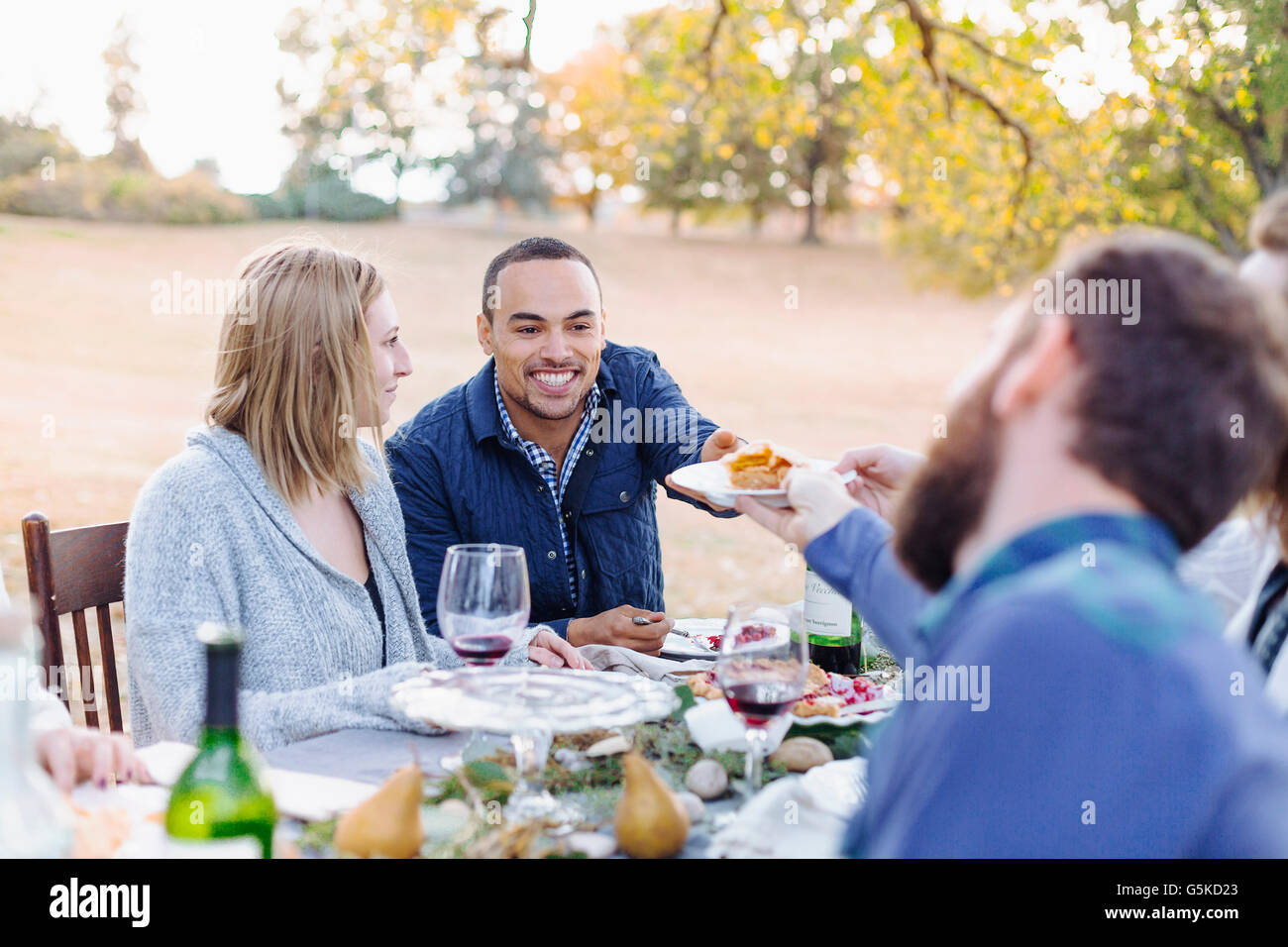 Friends eating pie at outdoor table Stock Photo - Alamy