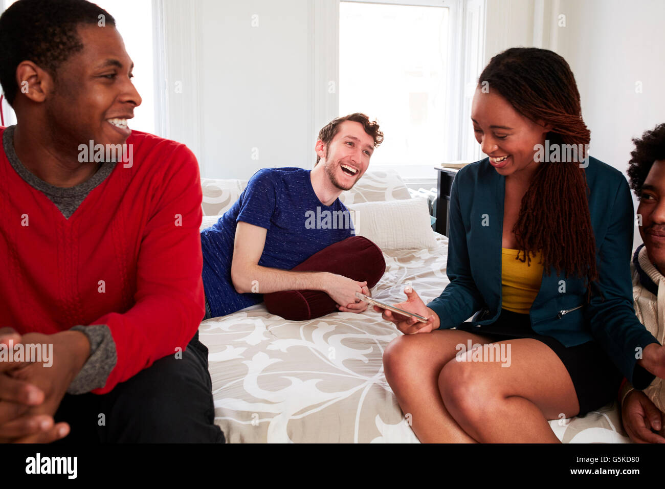 Friends relaxing in bedroom Stock Photo - Alamy