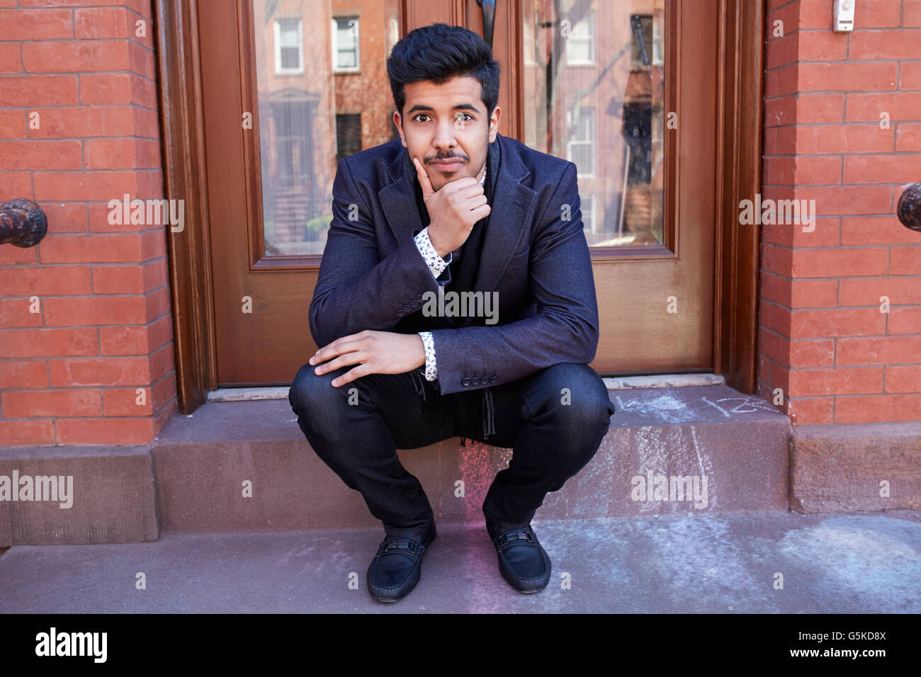 Middle Eastern man sitting on front stoop Stock Photo - Alamy