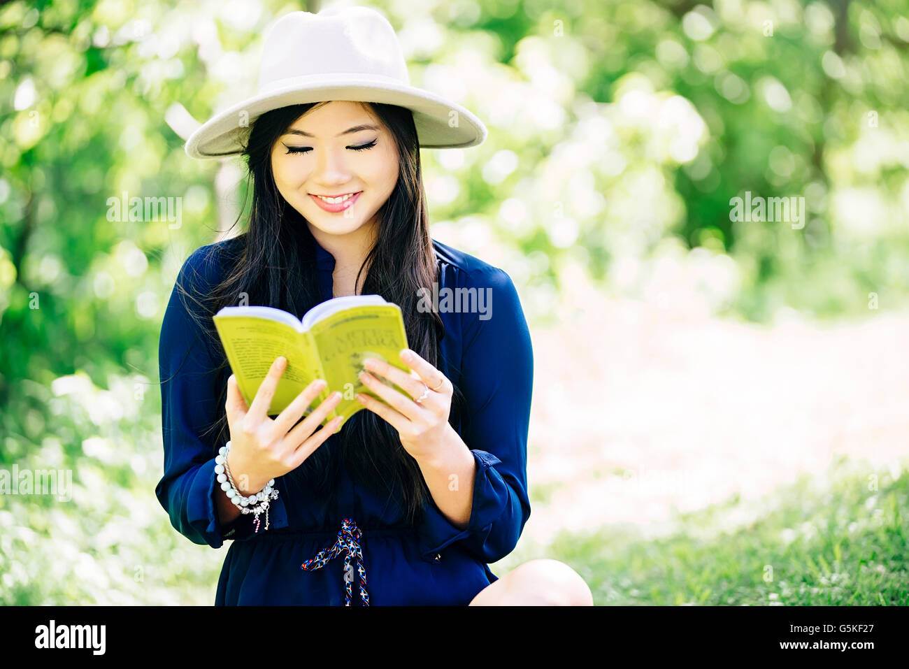 Chinese woman reading in garden Stock Photo - Alamy