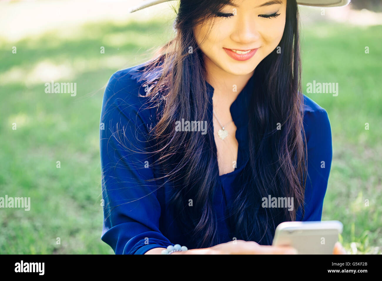 Chinese woman using cell phone outdoors Stock Photo - Alamy
