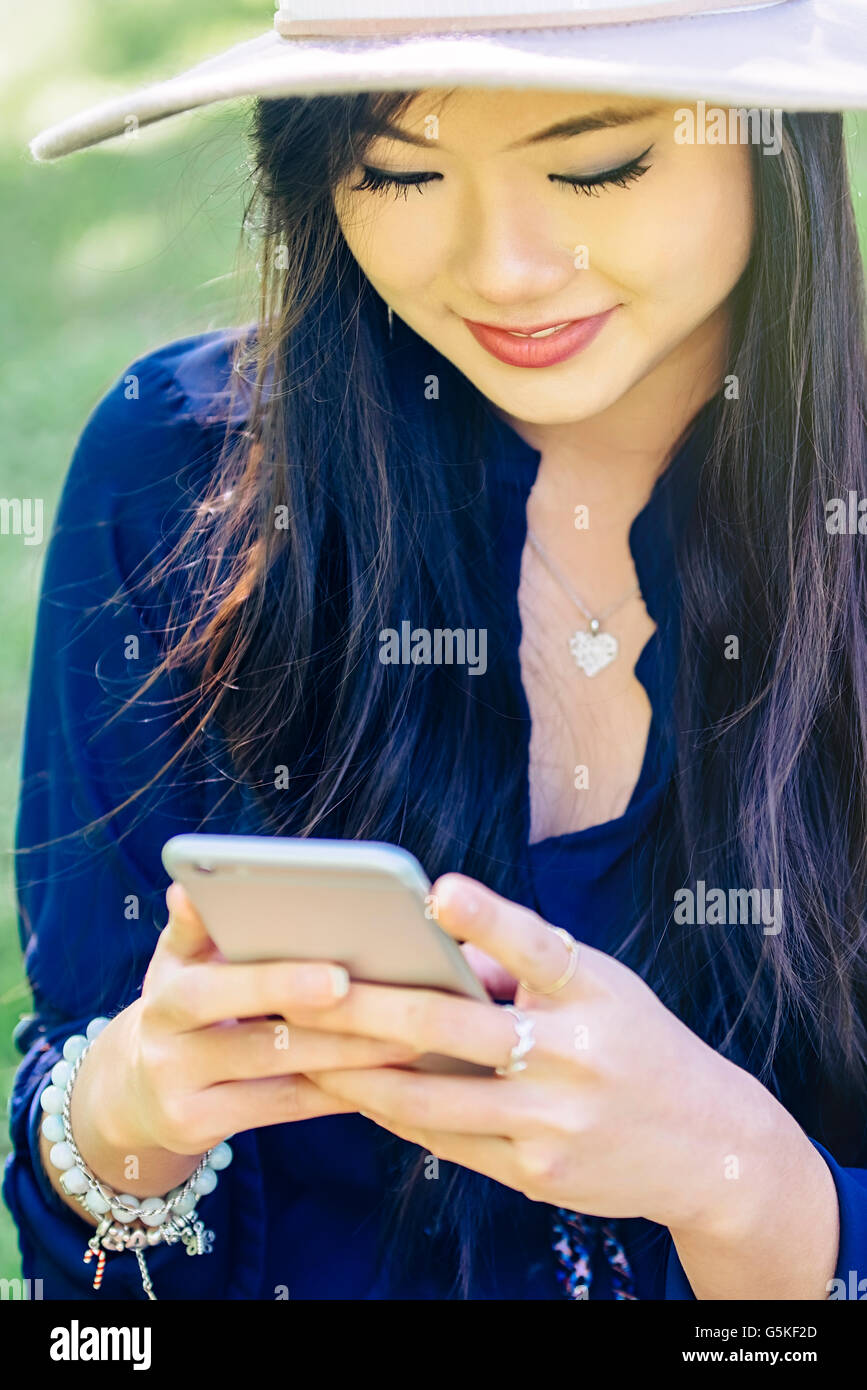 Chinese woman using cell phone outdoors Stock Photo - Alamy
