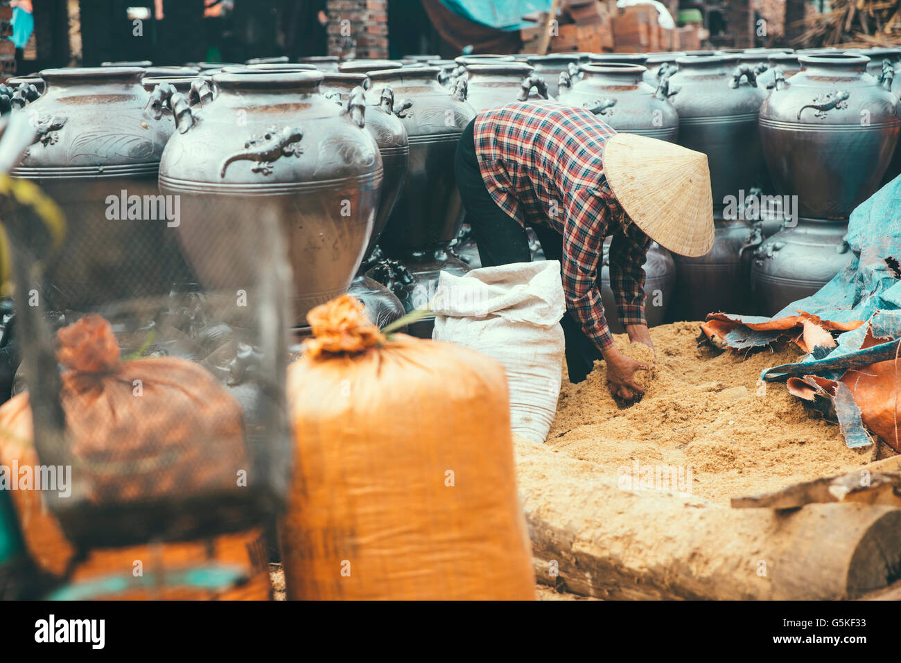 Vendor lifting grain into pots in market Stock Photo - Alamy