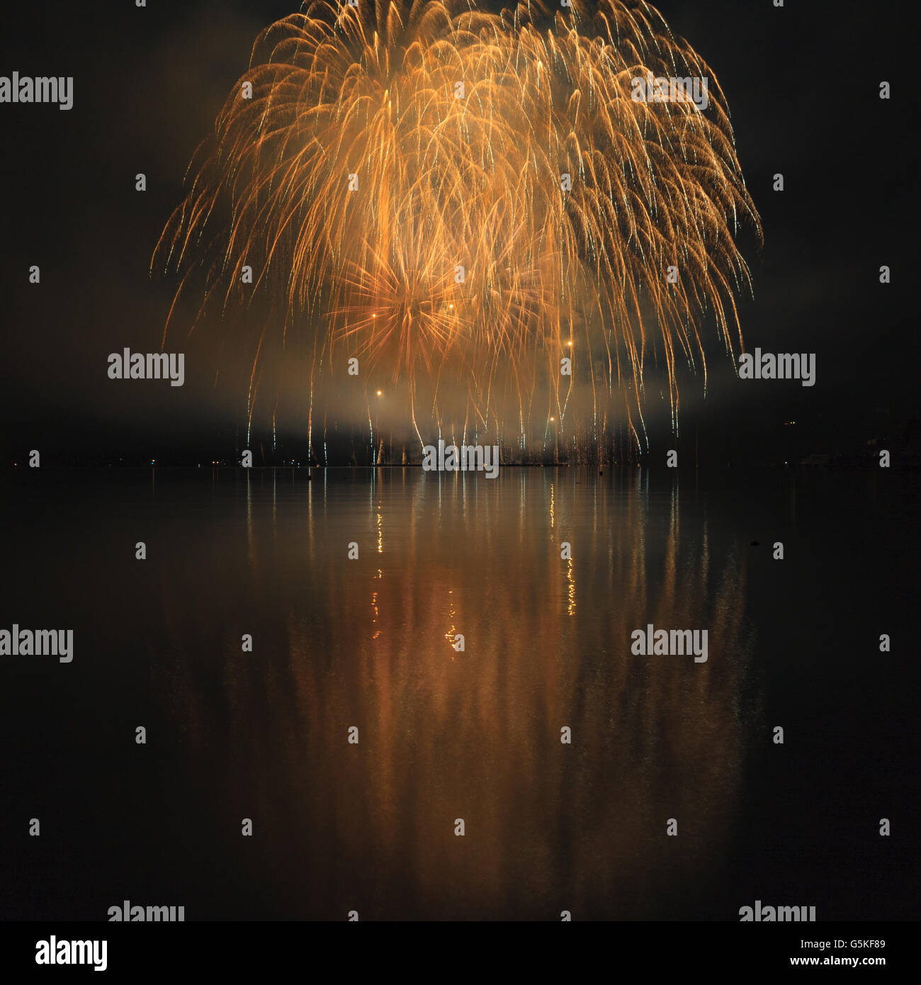 Colorful fireworks with reflection on lake and night sky in background ...