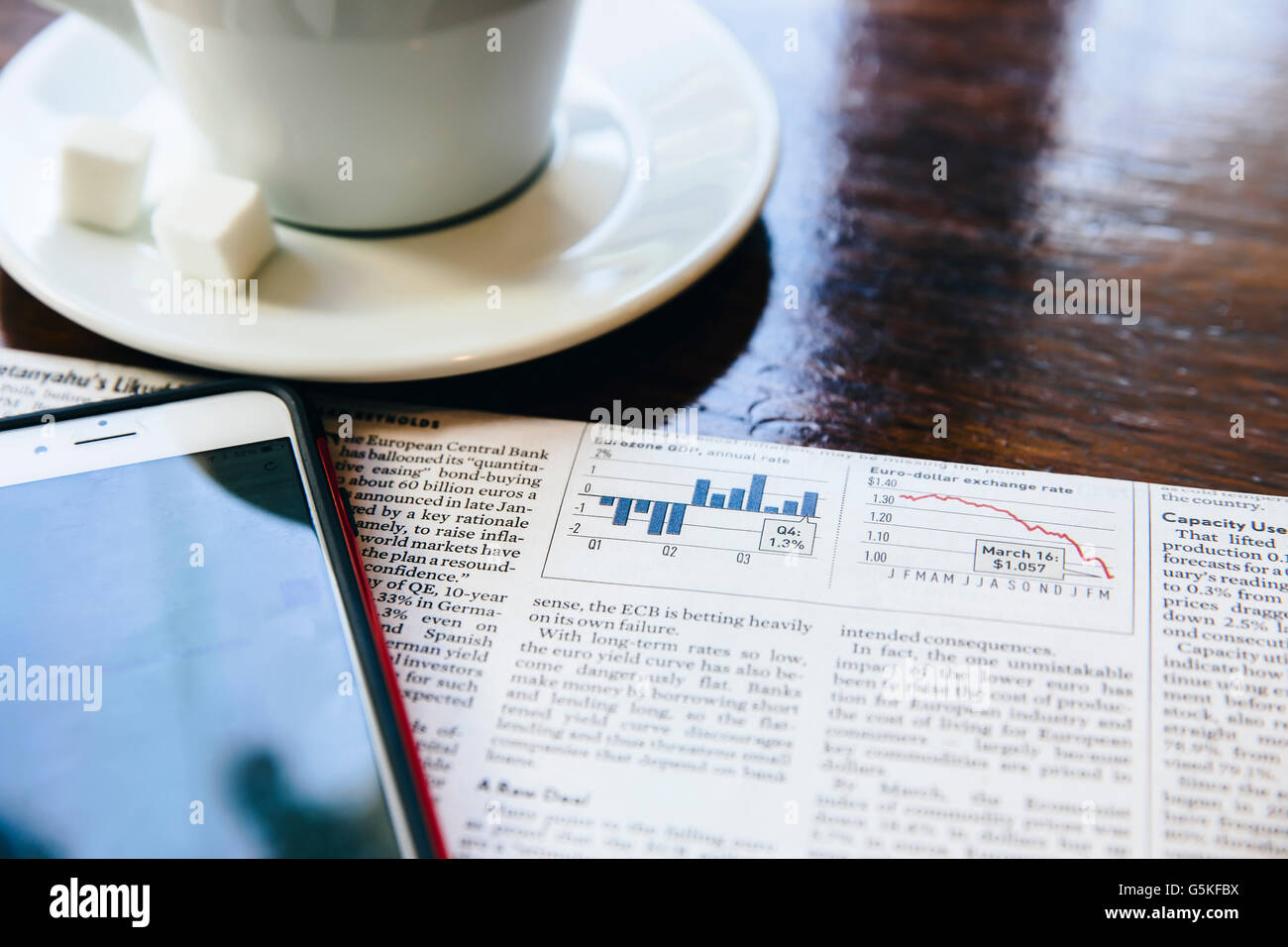 Cell phone, newspaper and coffee cup in cafe Stock Photo - Alamy