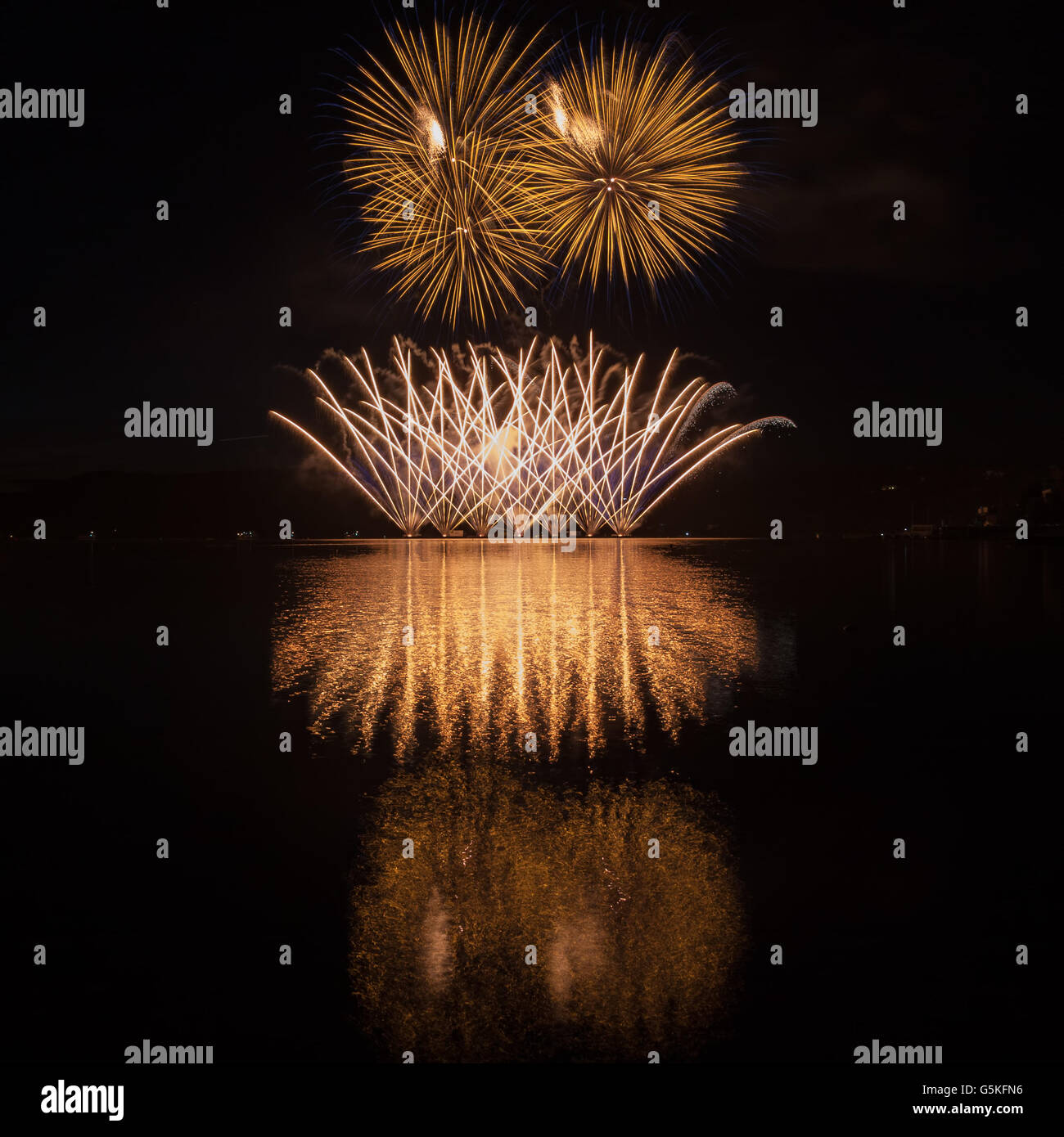 Colorful fireworks with reflection on lake and night sky in background ...