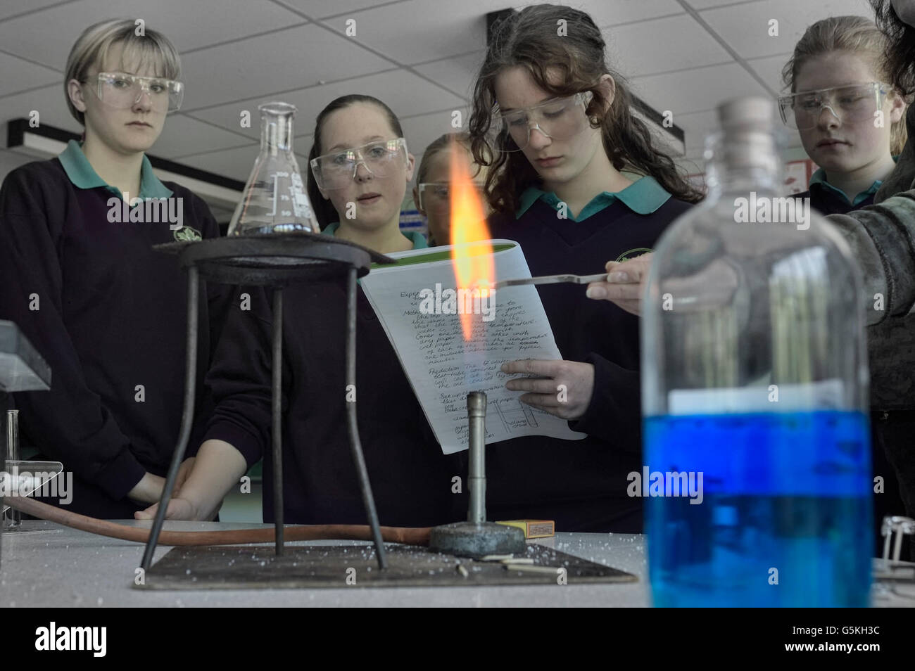 Schoolgirls conducting an experiment in the science classroom. England ...