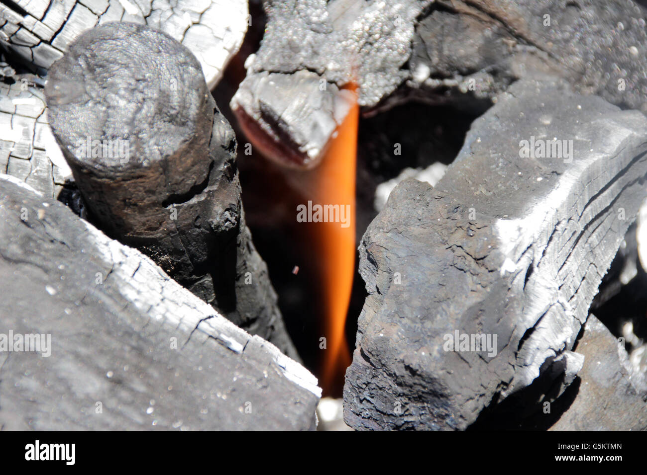 Photograph of some wood charcoal pieces and fire flames Stock Photo - Alamy