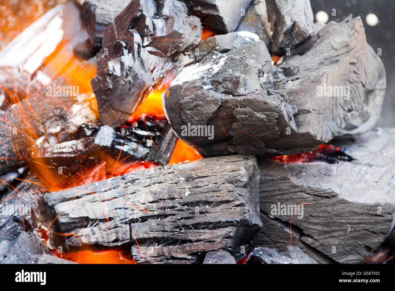 Photograph of some wood charcoal pieces and fire flames Stock Photo - Alamy