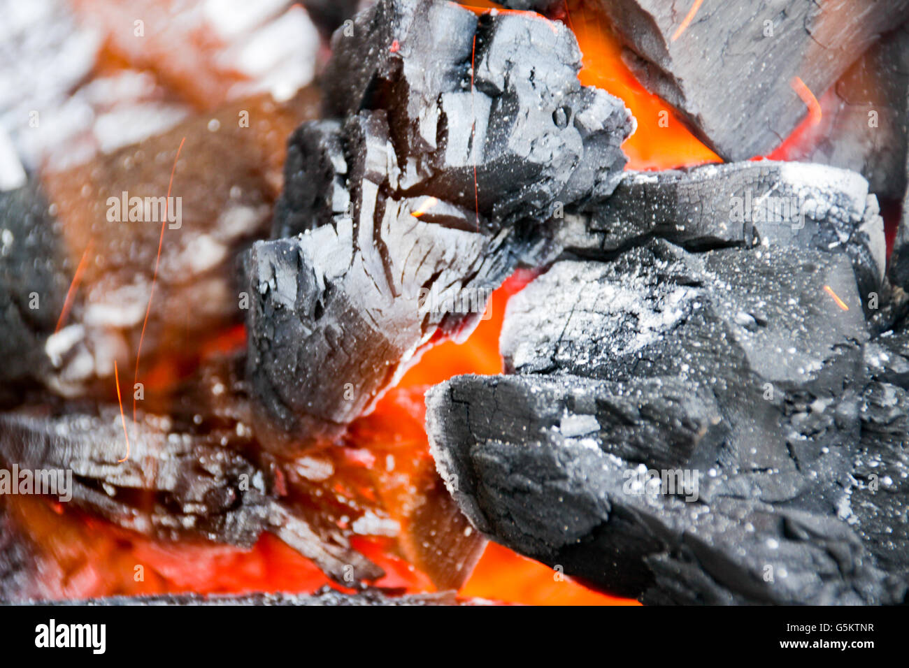 Photograph of some wood charcoal pieces and fire flames Stock Photo - Alamy