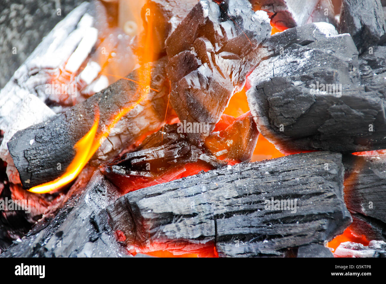 Photograph of some wood charcoal pieces and fire flames Stock Photo - Alamy