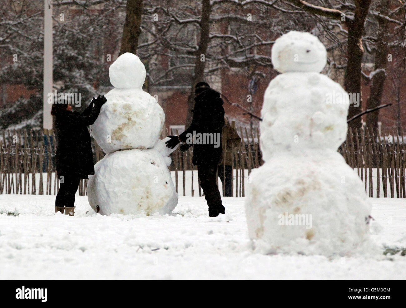 People building a snowman in St James Park, central London Stock Photo ...