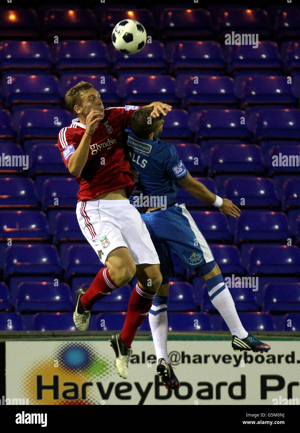 L-R; Wrexham's Neil Ashton and Stockport County's Tom Collins battle ...