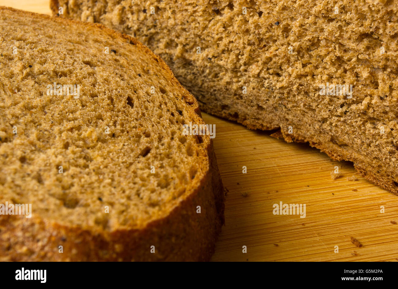 Sliced dark bread with crumbs on wood board Stock Photo - Alamy
