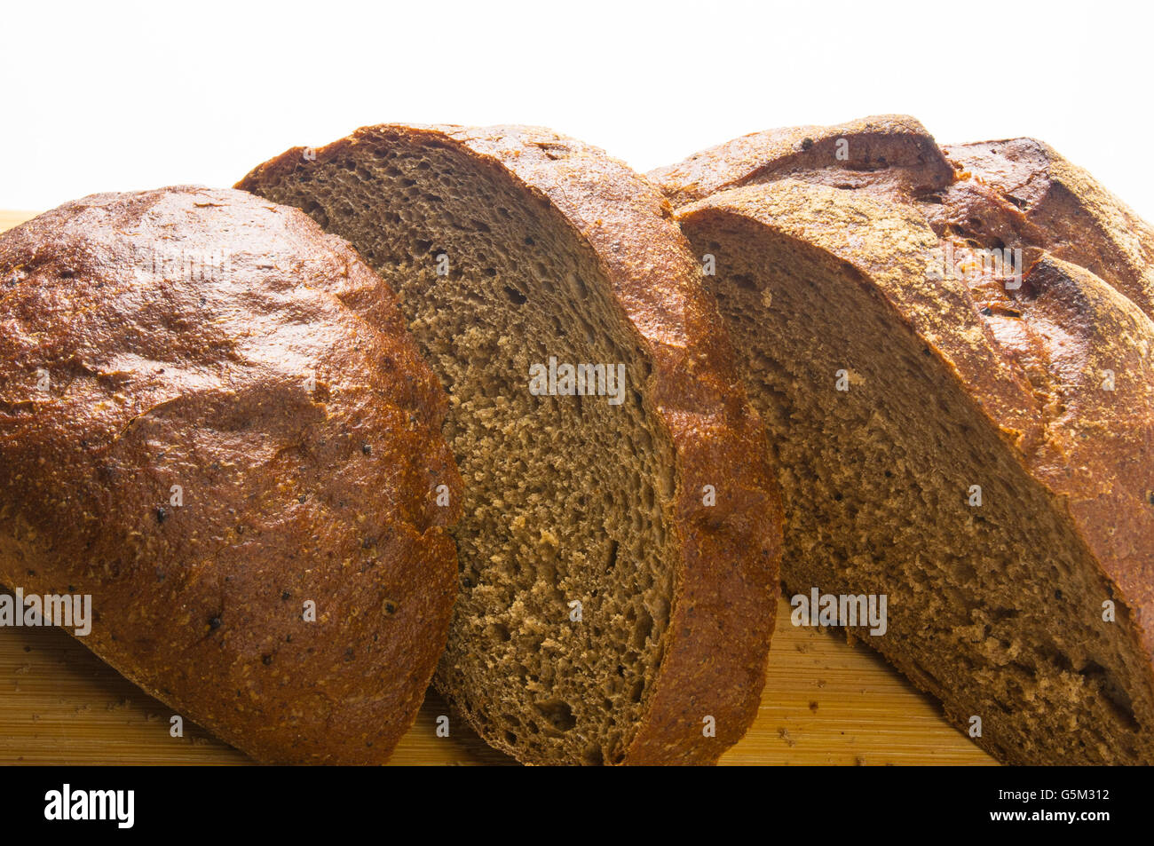 Sliced dark bread with crumbs on wood board Stock Photo - Alamy