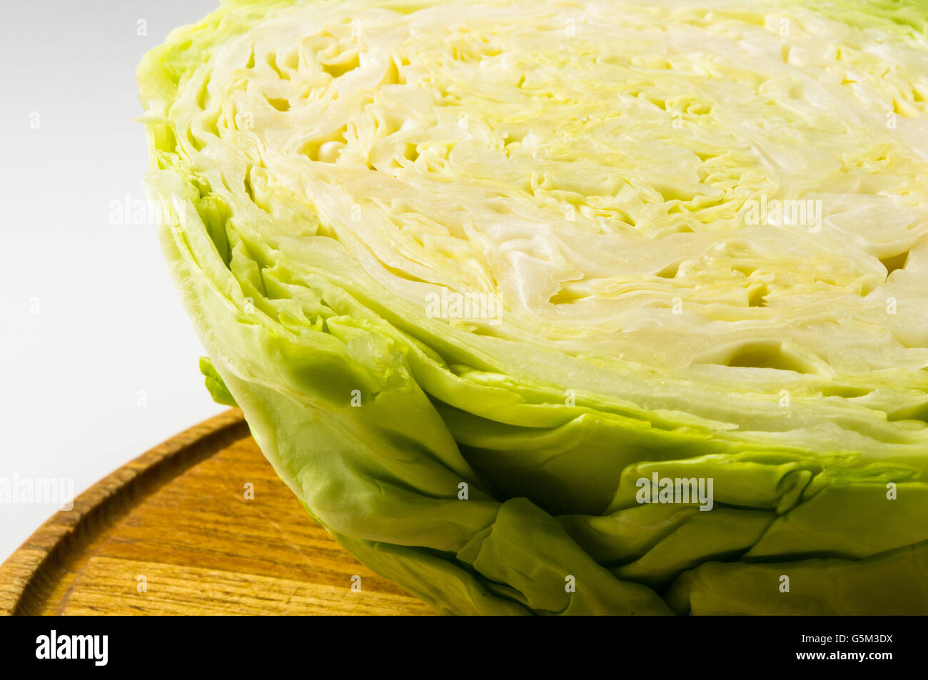half head of Early cabbage on a wooden Board, on a white background ...