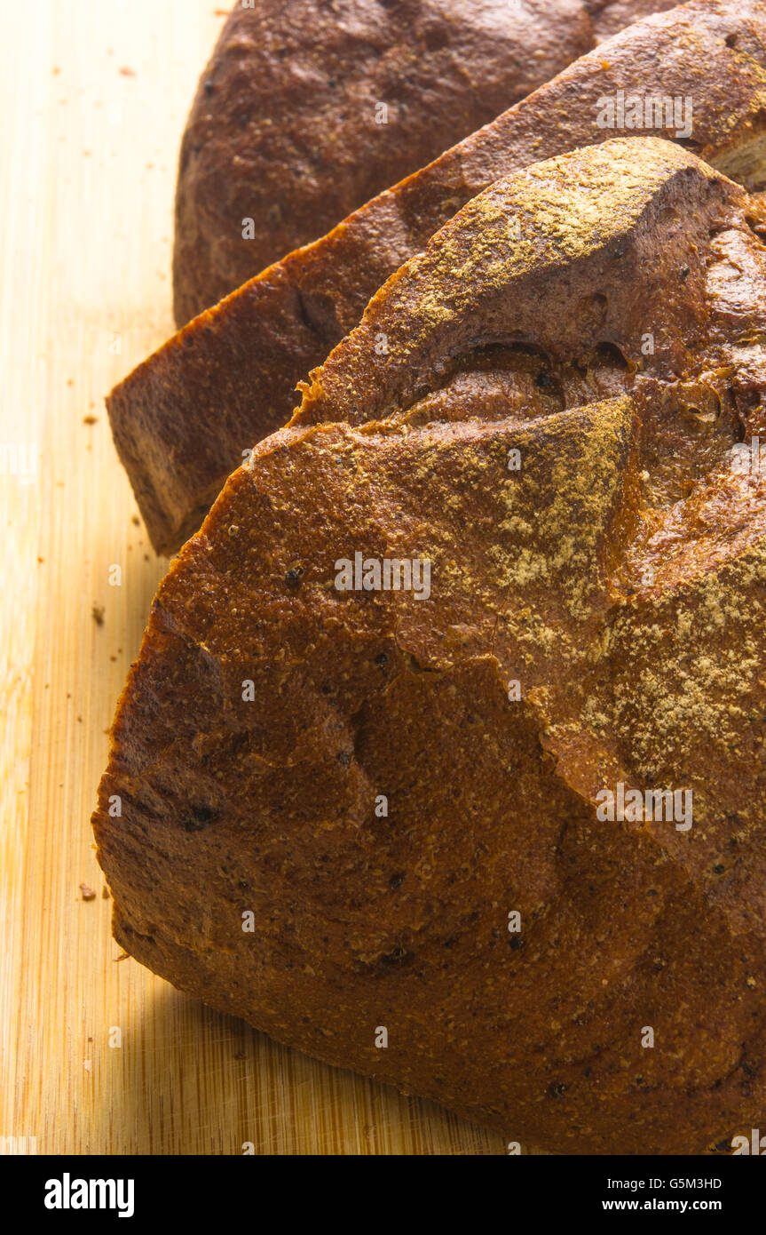 Sliced dark bread with crumbs on wood board Stock Photo - Alamy