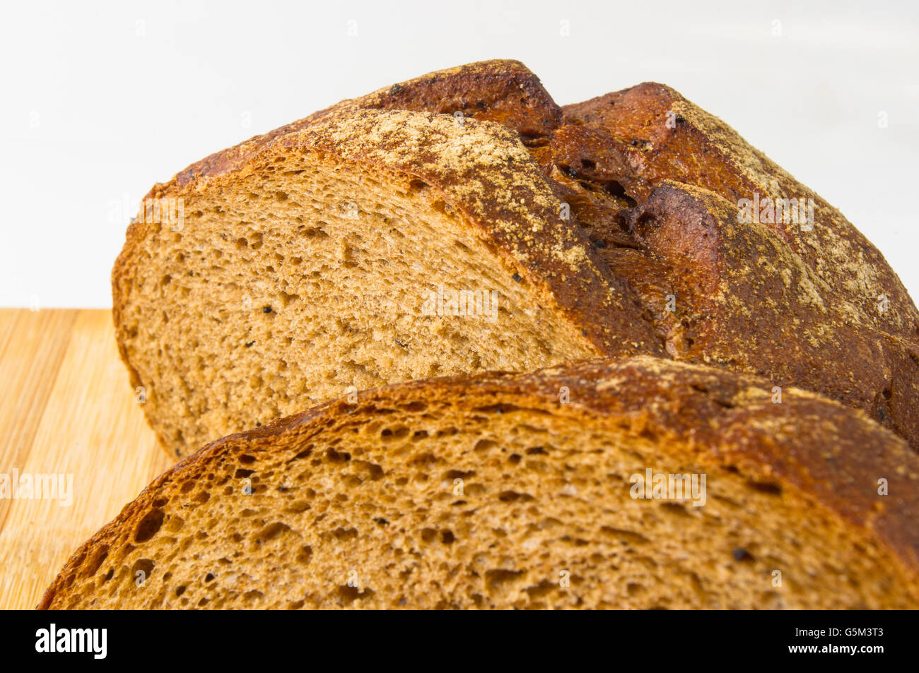 Sliced dark bread with crumbs on wood board Stock Photo - Alamy