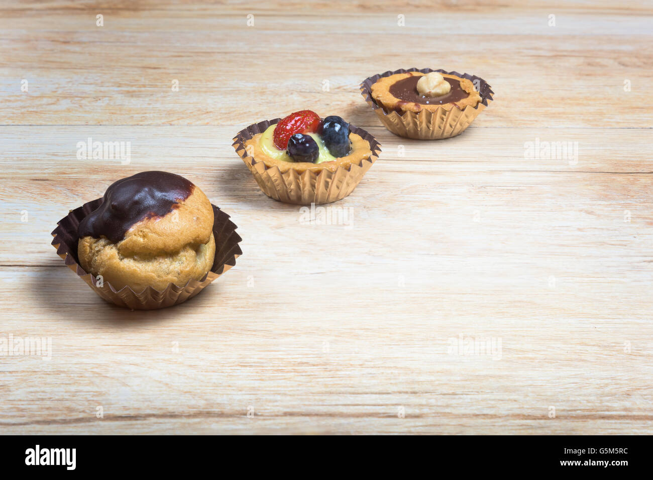 Pictured pastries on light wood background Stock Photo - Alamy