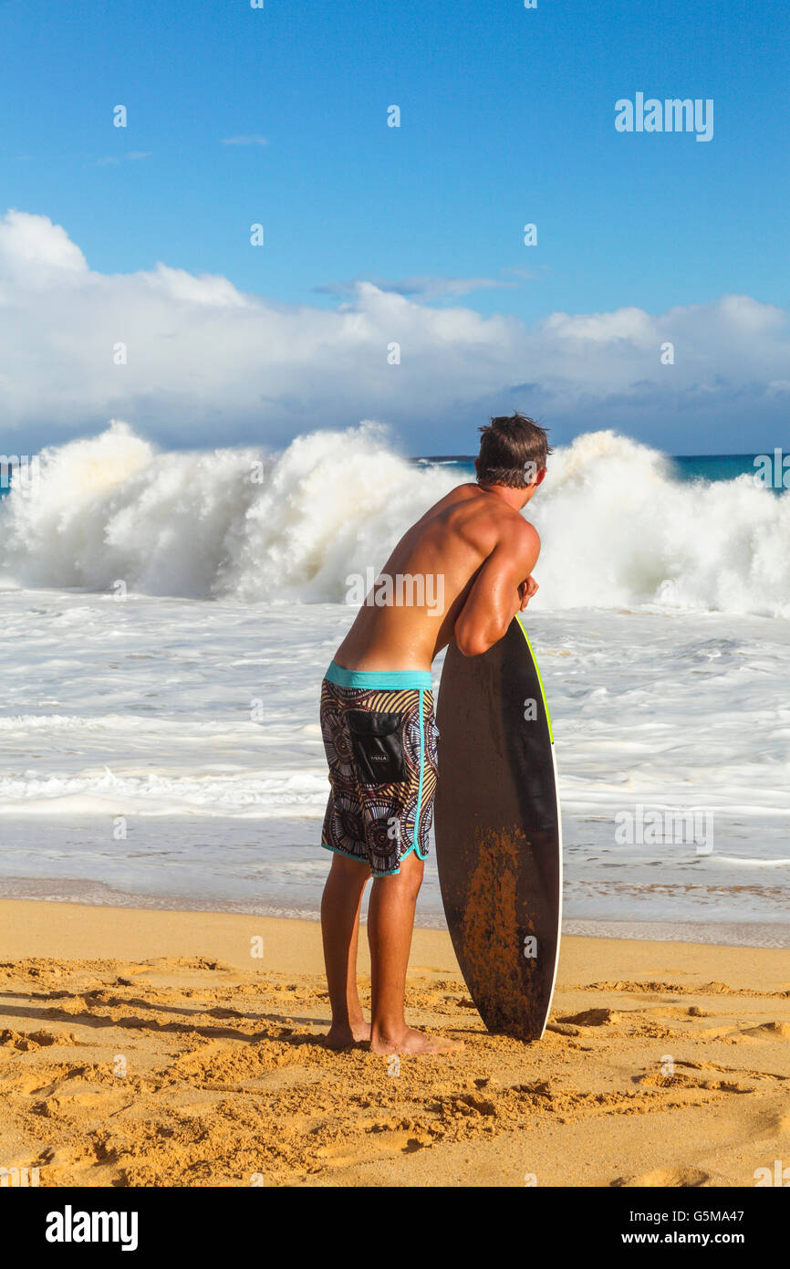 Skimboarder watches waves at Big Beach at Makena State Park Stock Photo ...