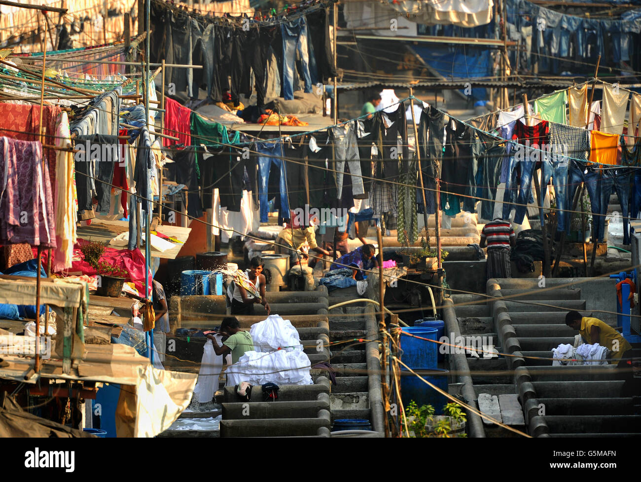 Washers, known locally as Dhobis, work in the open to wash clothes from ...
