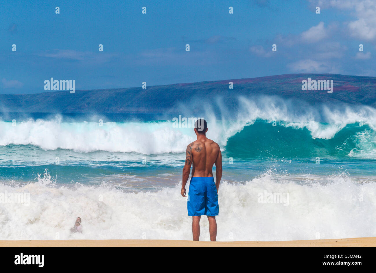 Man rides in wave as friend looks on at Big Beach in Makena State Park ...