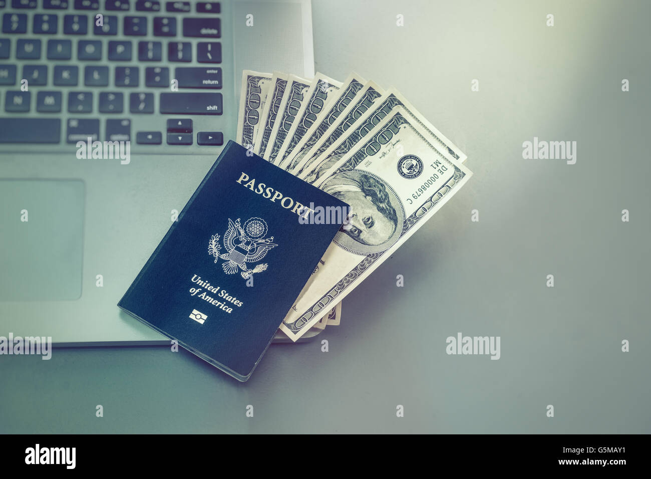 Lets travel abroad - passport cash on laptop Stock Photo - Alamy
