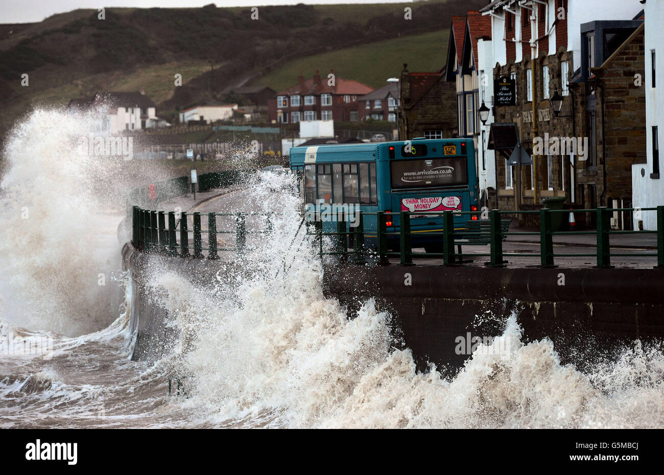 Waves crash against the sea wall at sandsend hi-res stock photography ...