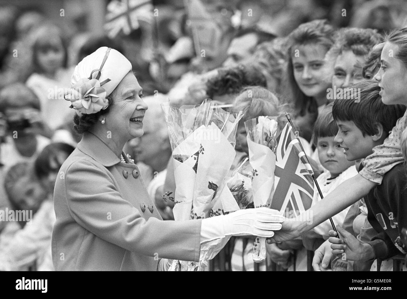 Well-wishers congratulate and hand flowers to the Queen during her ...