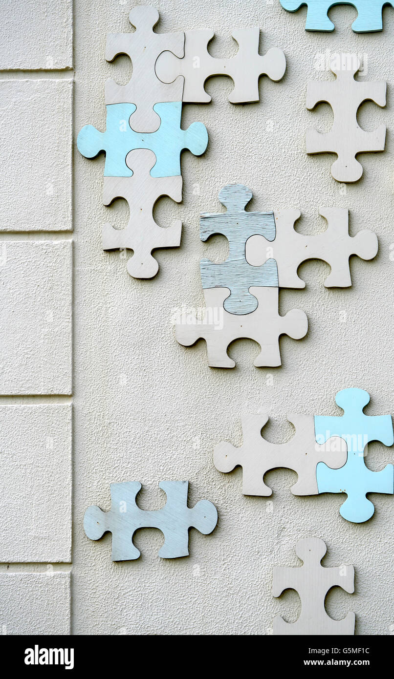 white wall with white and blue puzzle pieces Stock Photo - Alamy
