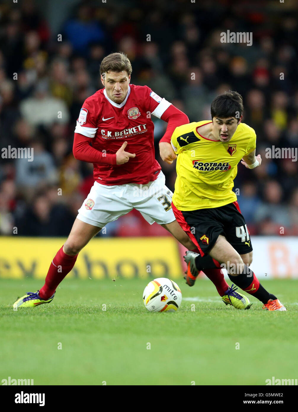 Watford's Fernando Forestieri is challenged by Barnsley's Akos Buzsaky ...