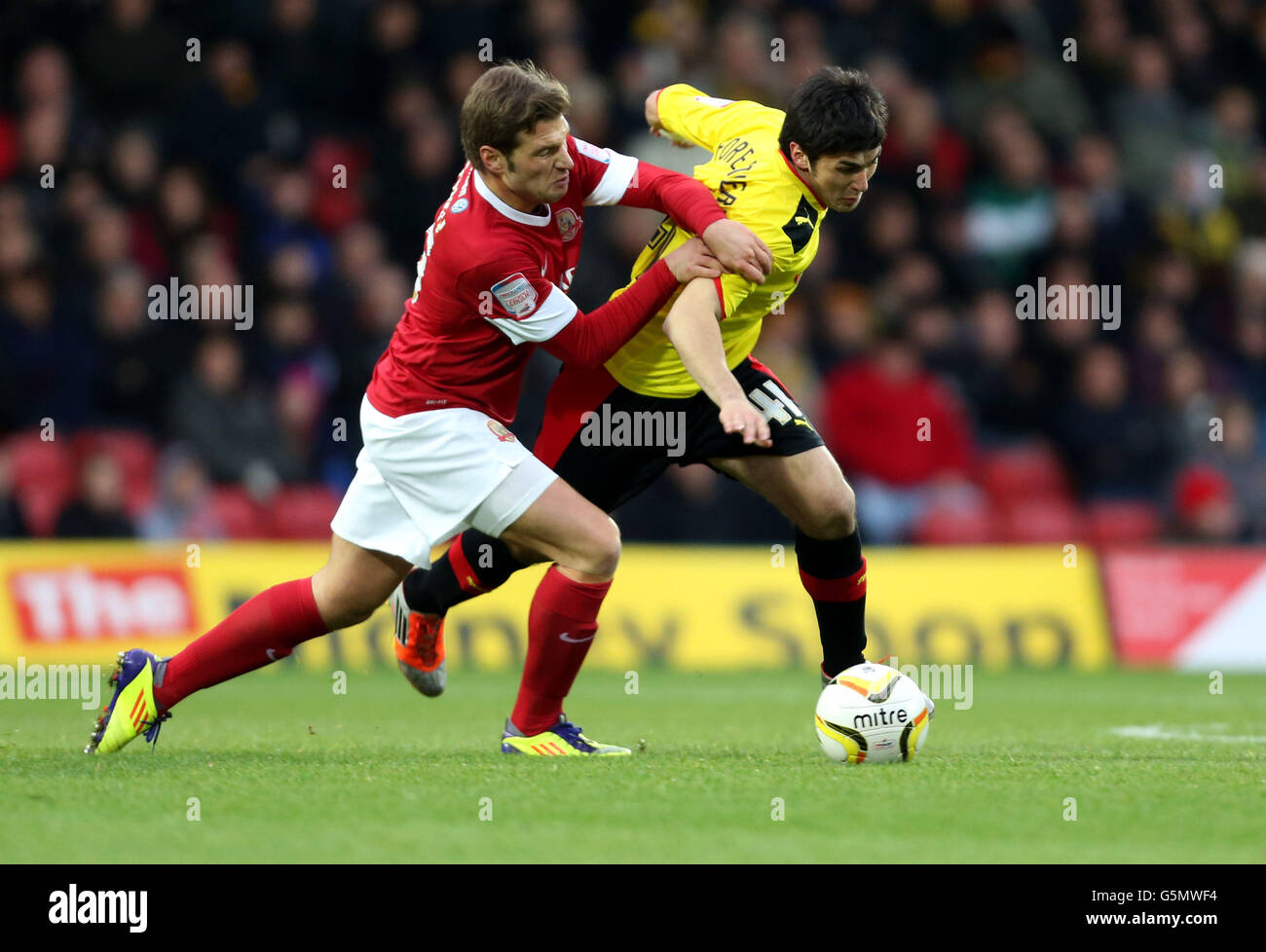 Watford's Fernando Forestieri is challenged by Barnsley's Akos Buzsaky ...