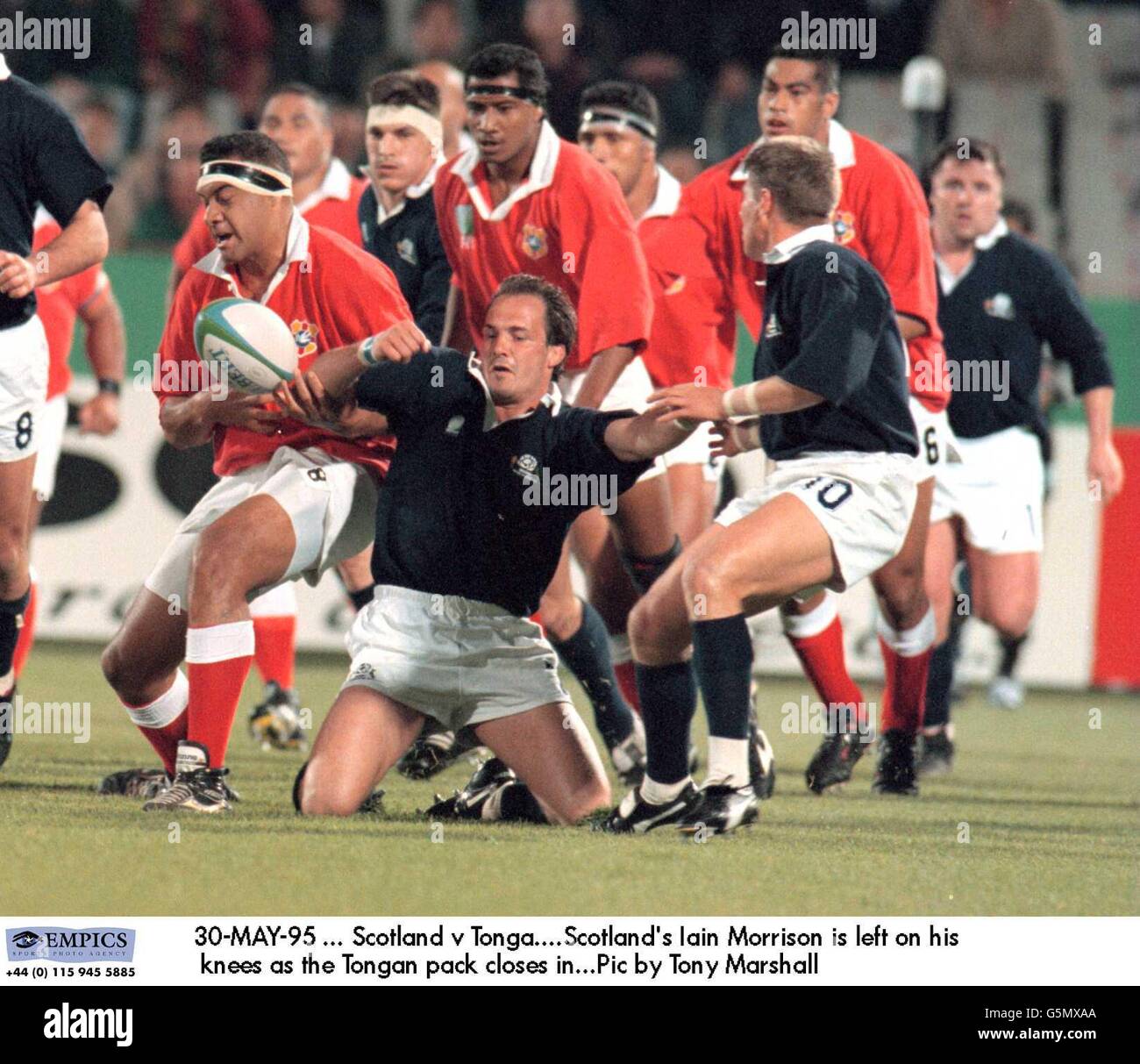 Scotland's Iain Morrison is left on his knees as the Tongan pack closes ...