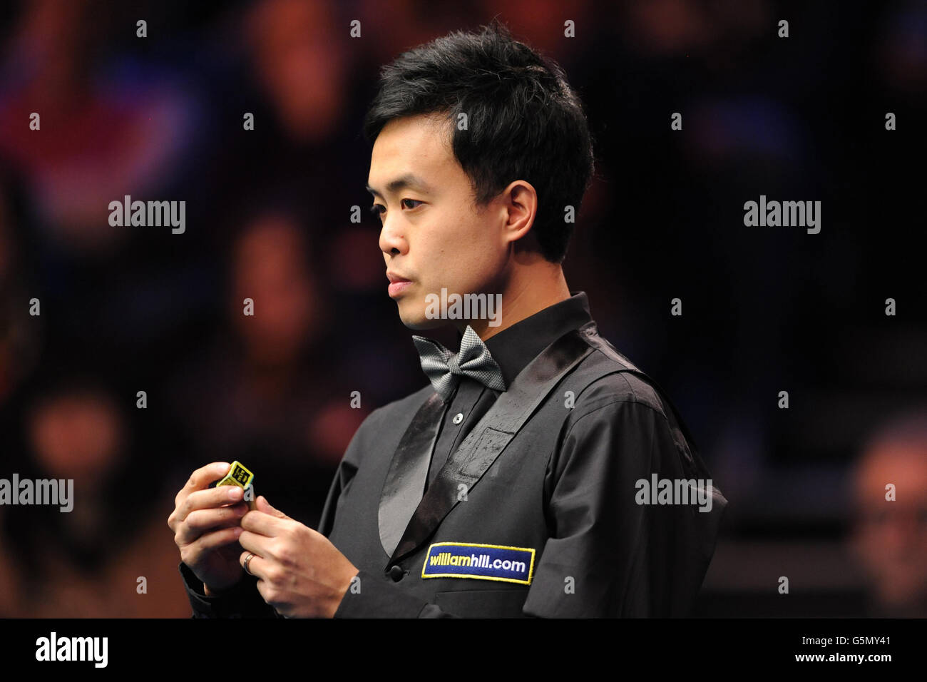 Marco Fu chalks his cue during his second round match against Matthew ...