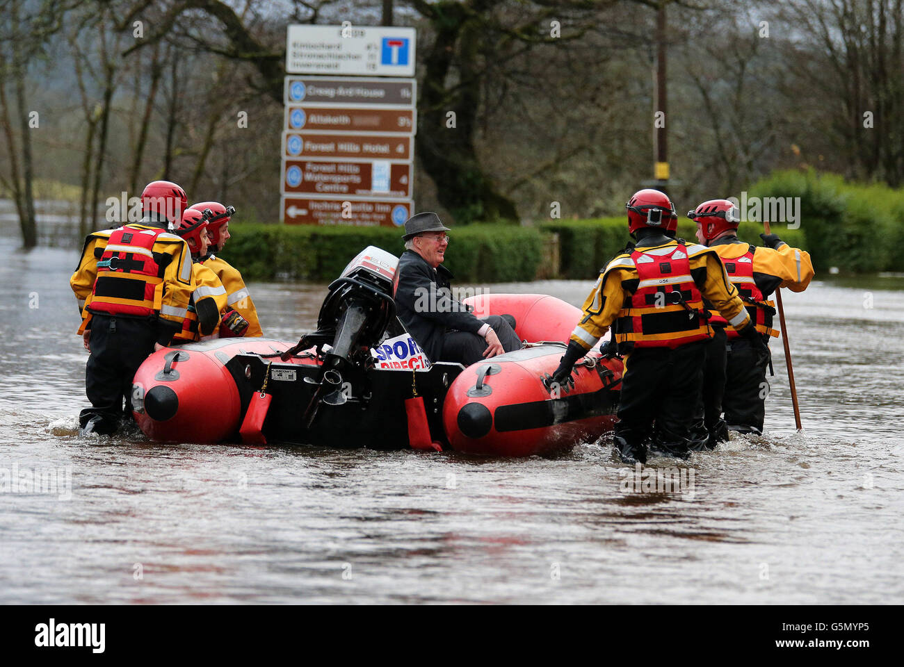 Firemen help a member of the public in Aberfoyle which has been flooded ...